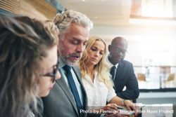 Group Of Serious Colleagues Standing Having A Conversation At Work ...