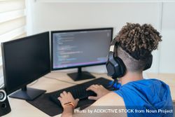 Software engineer sitting at desk and typing on computer keyboard while ...