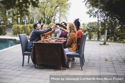 A Diverse Group Of Friends Cheerfully Toasting With Drinks At An ...