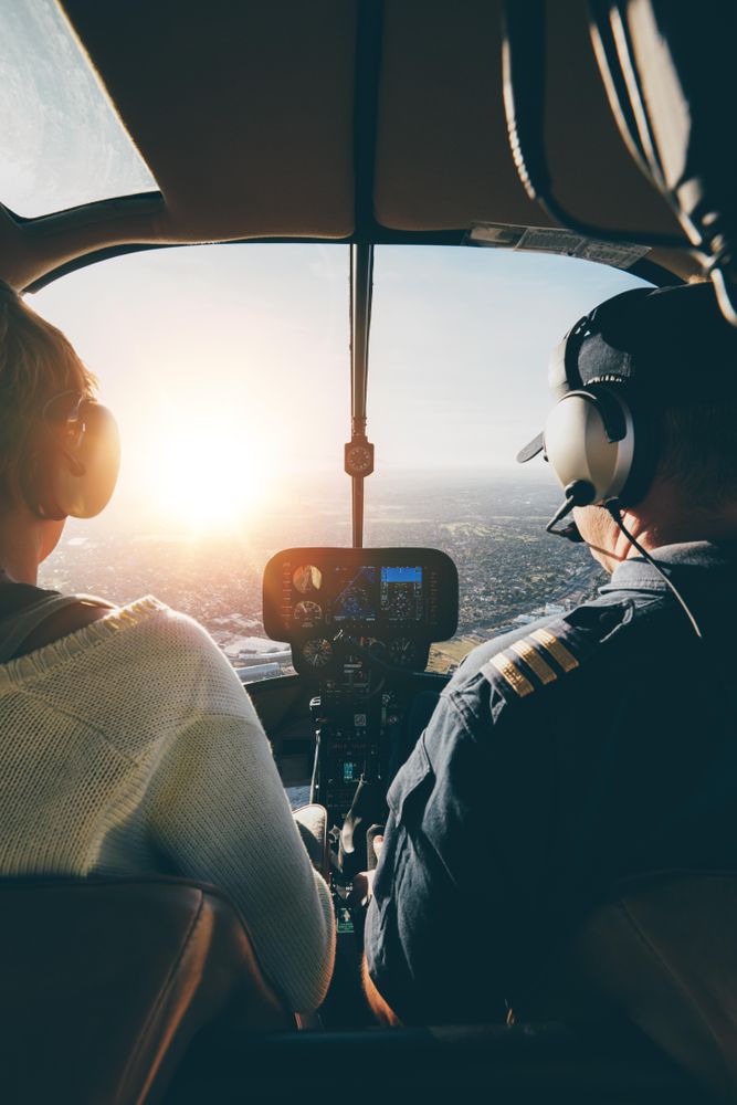 Rear view of two pilots flying a helicopter on sunny day - Premium ...