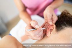 Therapist Using Ear Pen For Auriculotherapy Treatment Female Client ...