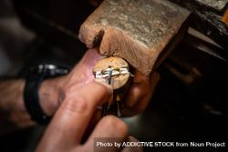 Jeweler hands setting a diamond into a ring with a burin in a jewelry workshop. Goldsmith ...
