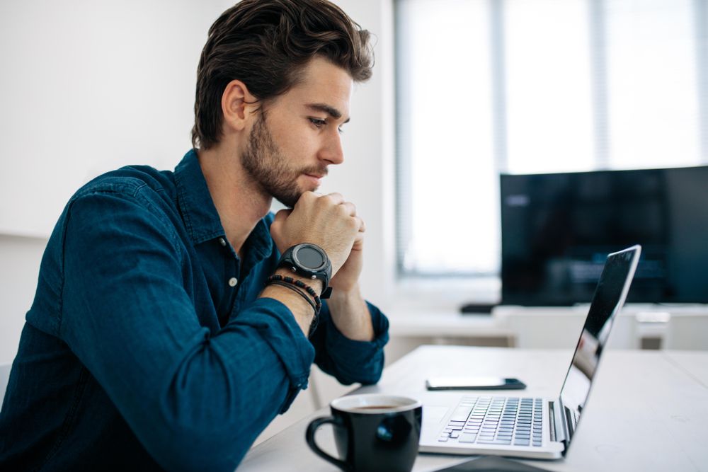 Software developer sitting in front of computer and working in office ...