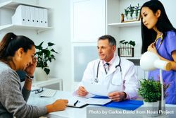Concerned doctor discussing file with patient in office - Premium Photo ...