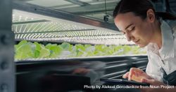 Female Biology Scientist Closely Inspecting and Analyzing Young Growing ...