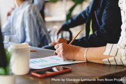 Close-Up Of Woman's Hand Taking Notes On Chart Paper In Office Meeting ...